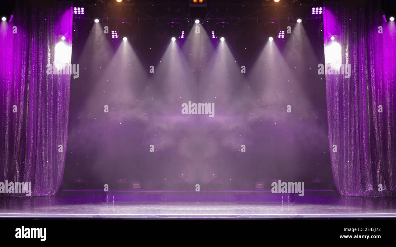 An empty stage of the theater, lit by spotlights and smoke before the ...