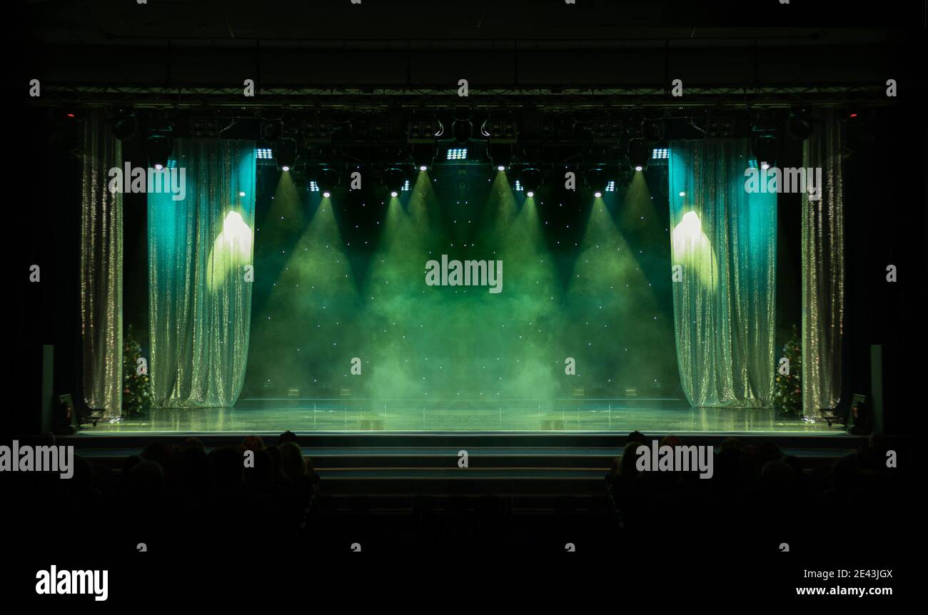 An empty stage of the theater, lit by spotlights and smoke before the ...