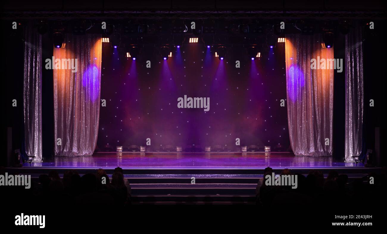 An empty stage of the theater, lit by spotlights and smoke before the ...