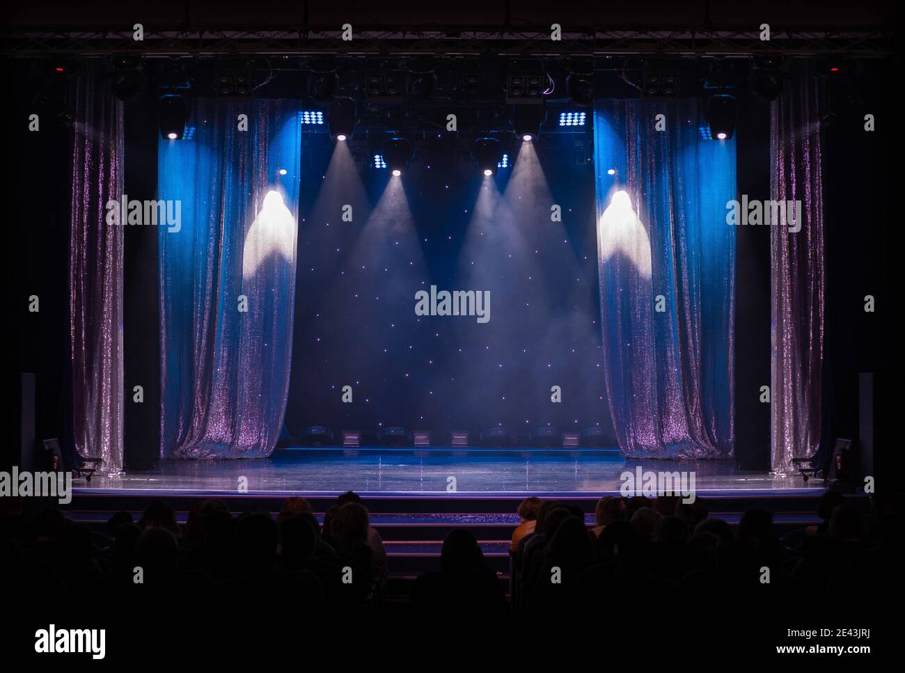An empty stage of the theater, lit by spotlights and smoke before the ...