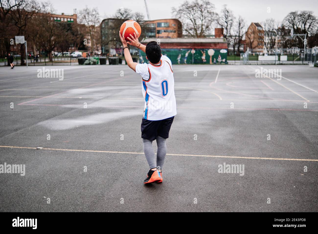 Unrecognizable basketball player at a court giving his back to the ...