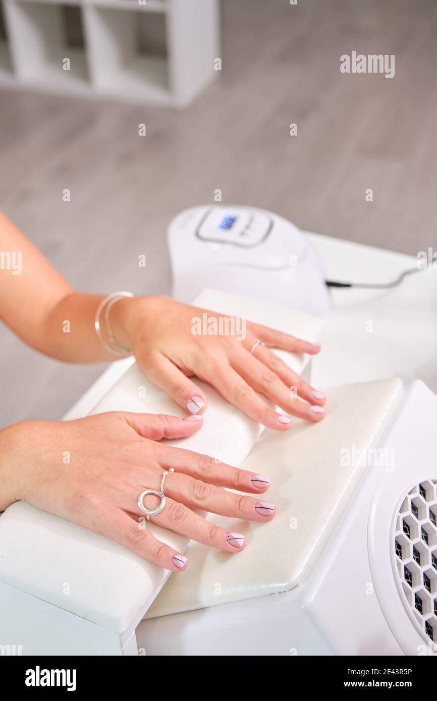 Crop anonymous female client keeping palms on hand rest stand during ...