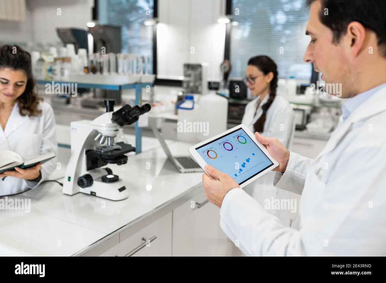 Side view of male scientist working with diagrams representing results ...