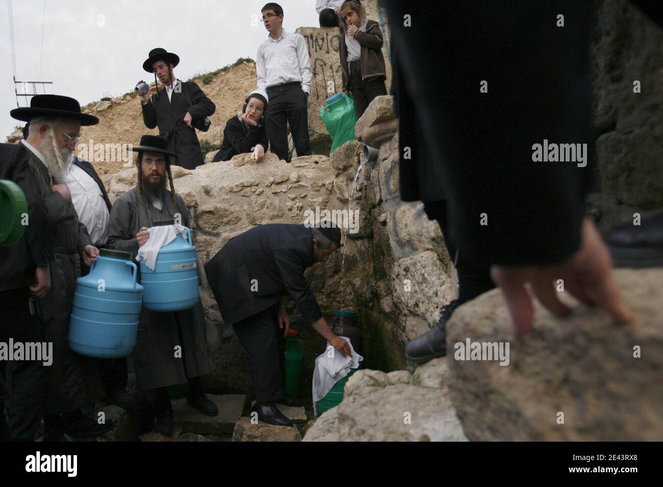 Ultra-Orthodox Jews fill their plastic containers with water from an ...