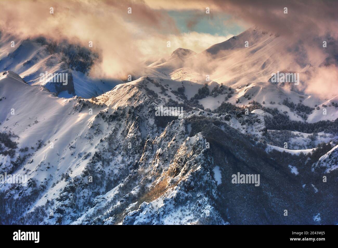 Spectacular landscape of mountain range covered with snow at sunset in ...