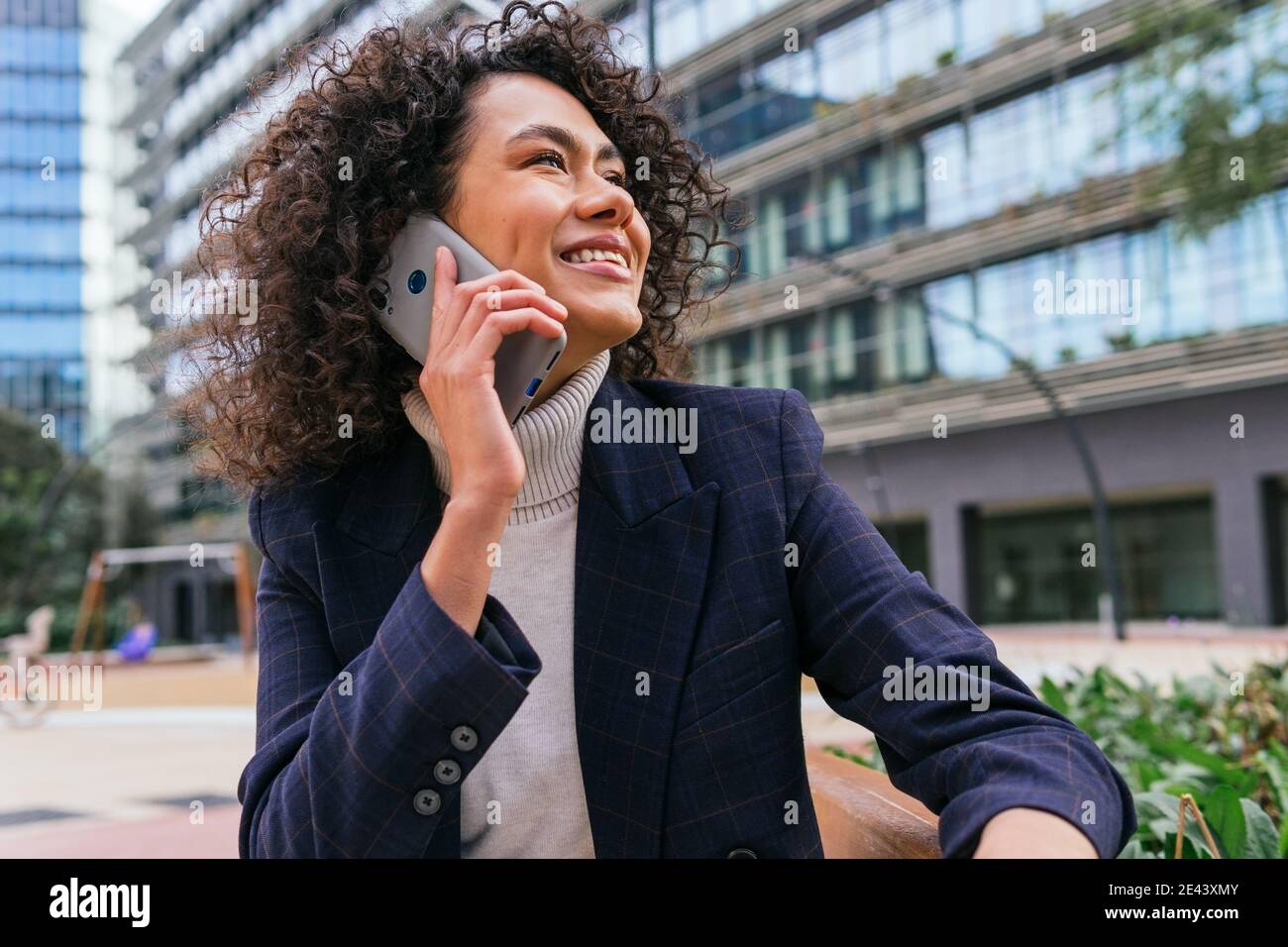 Low angle of confident smiling young ethnic female entrepreneur in ...