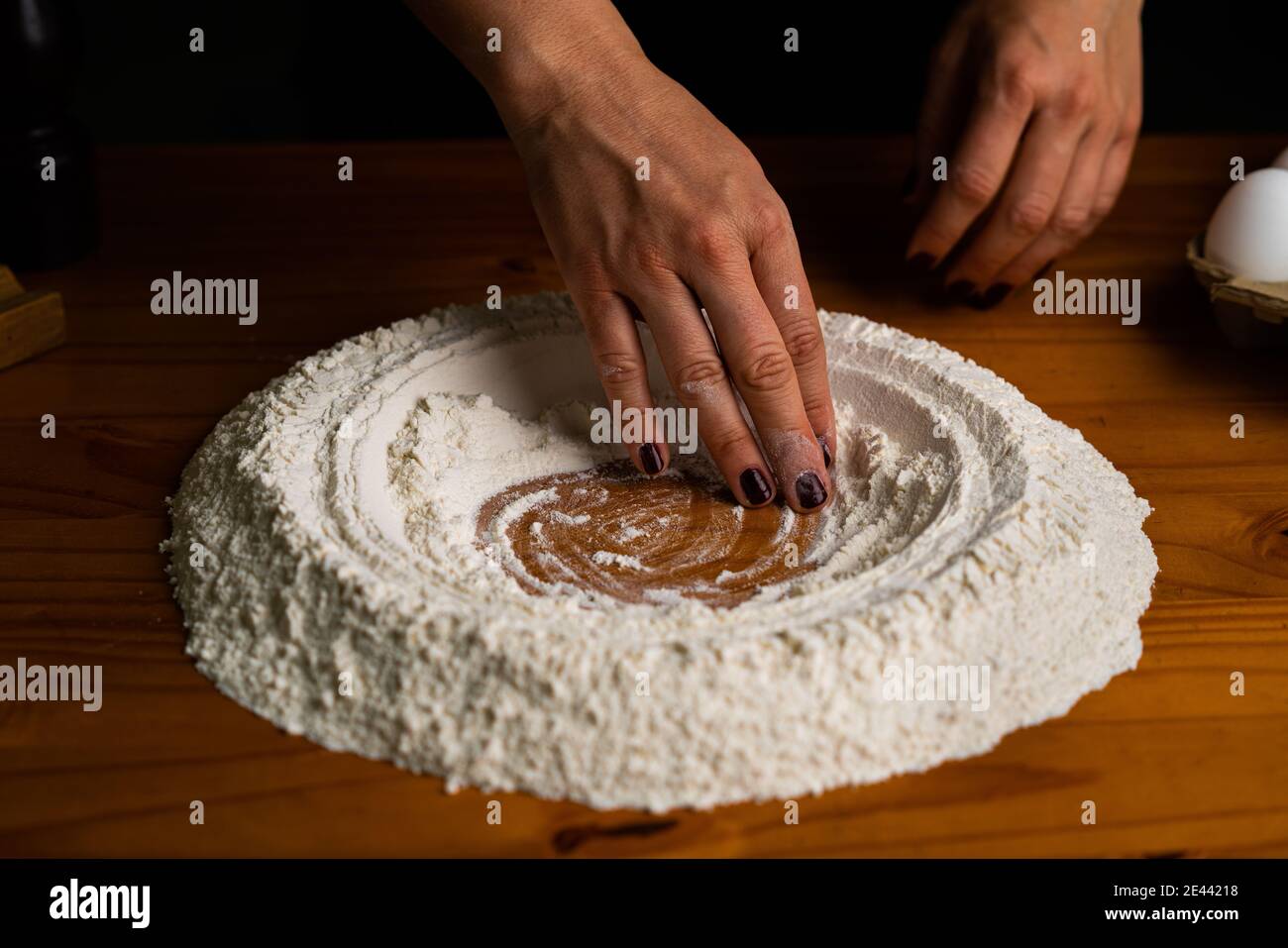 High angle of crop female making hollow in pile of wheat flour on ...
