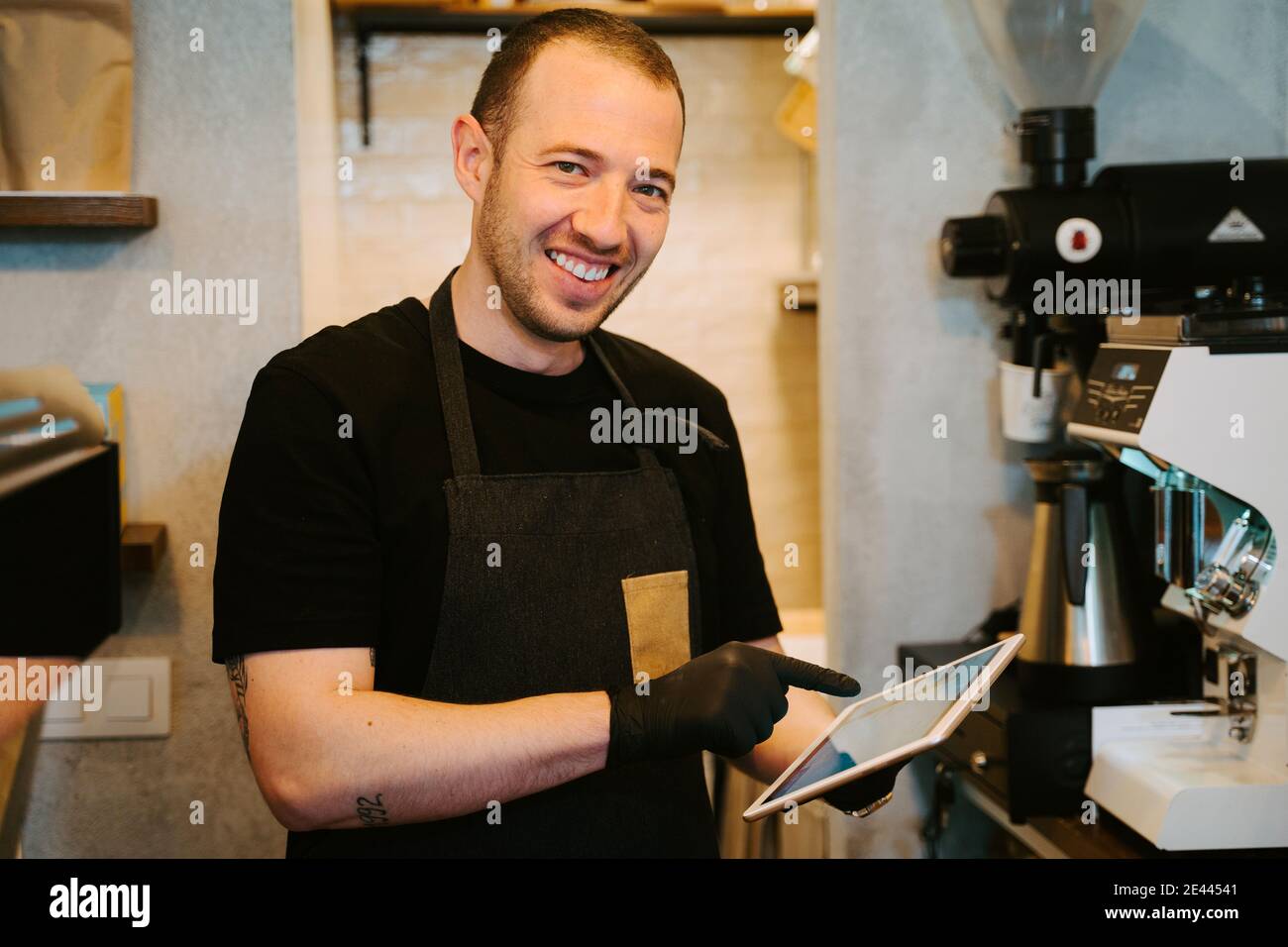 Waiter holding a tablet in hand while working in a coffee shop Stock ...
