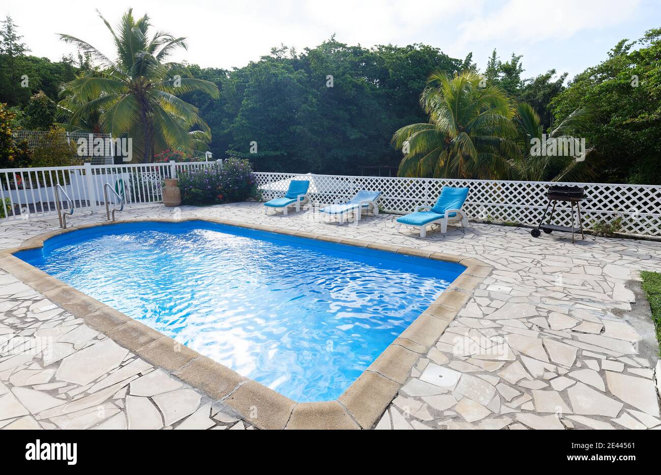 Beach chairs or pool bed around swimming pool with coconut trees in the ...