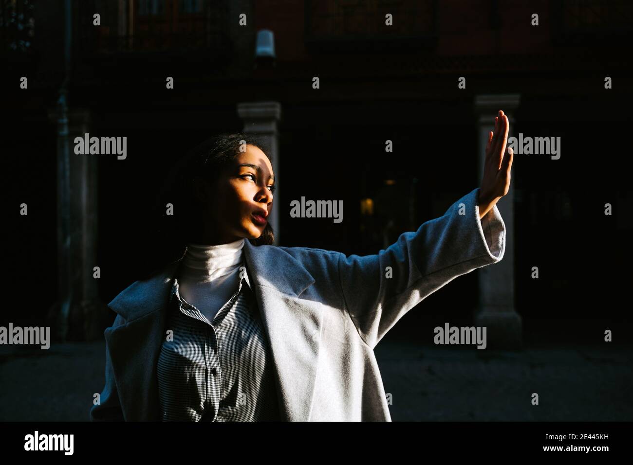 Full body of young ethnic female in stylish autumn outfit outstretching ...