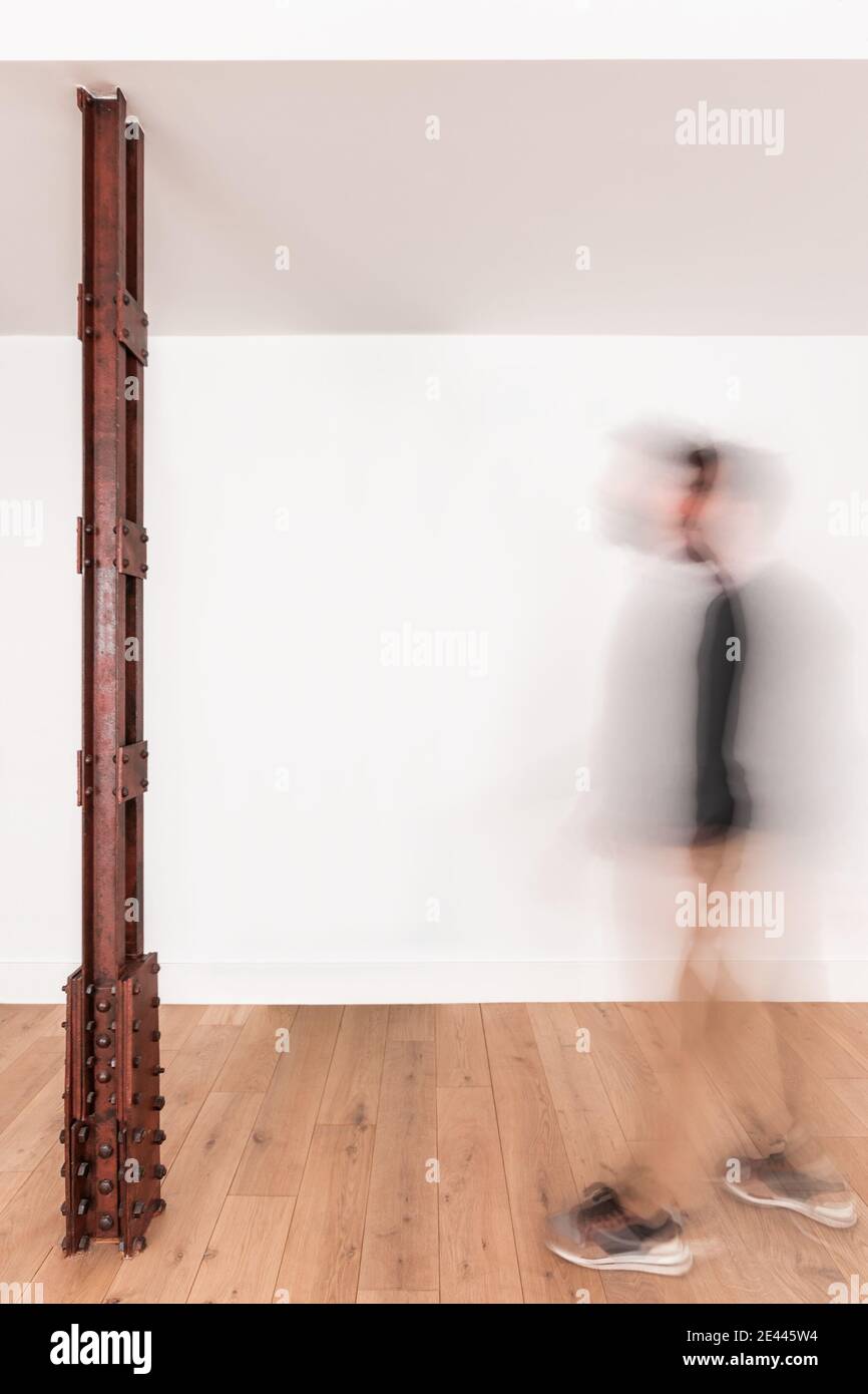 Side view of unrecognizable male observing art object in shape of iron ...