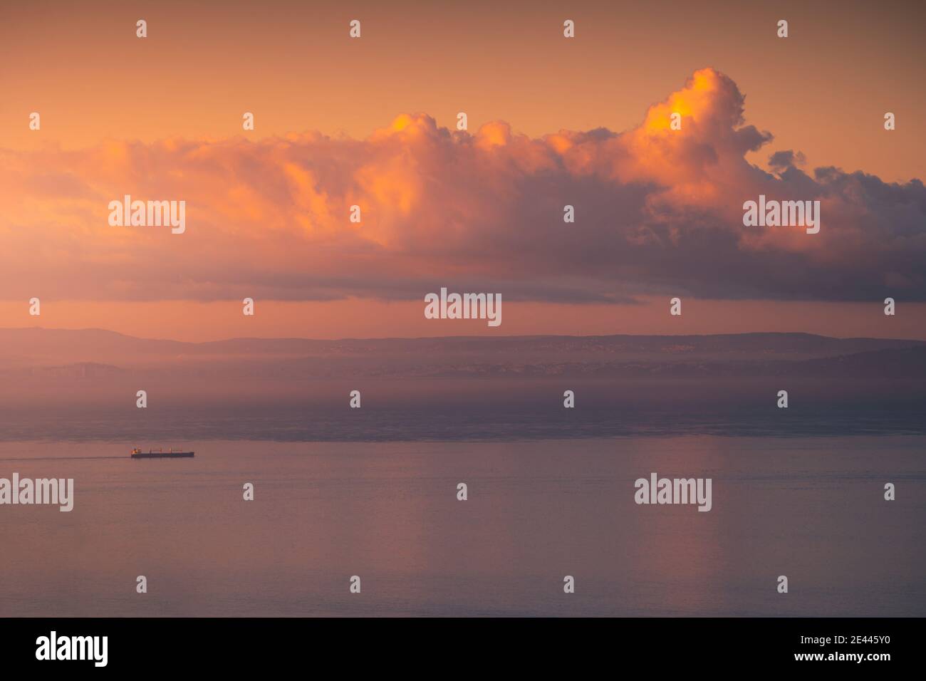 Boats floating in calm sea under sky with clouds illuminated by sunset ...