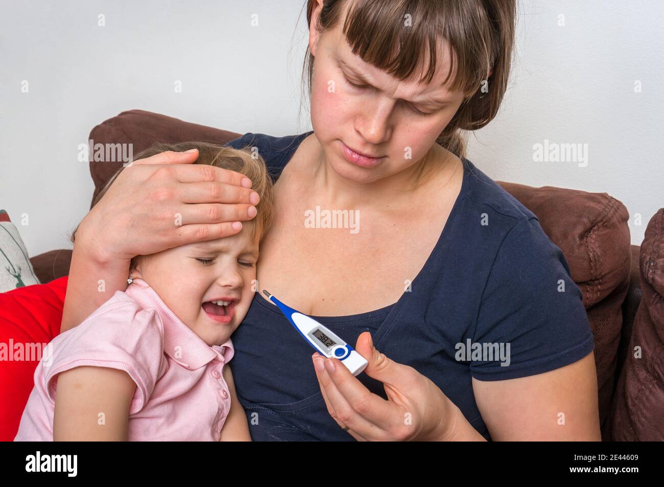 Sick child with fever and worried mother with thermometer Stock Photo ...