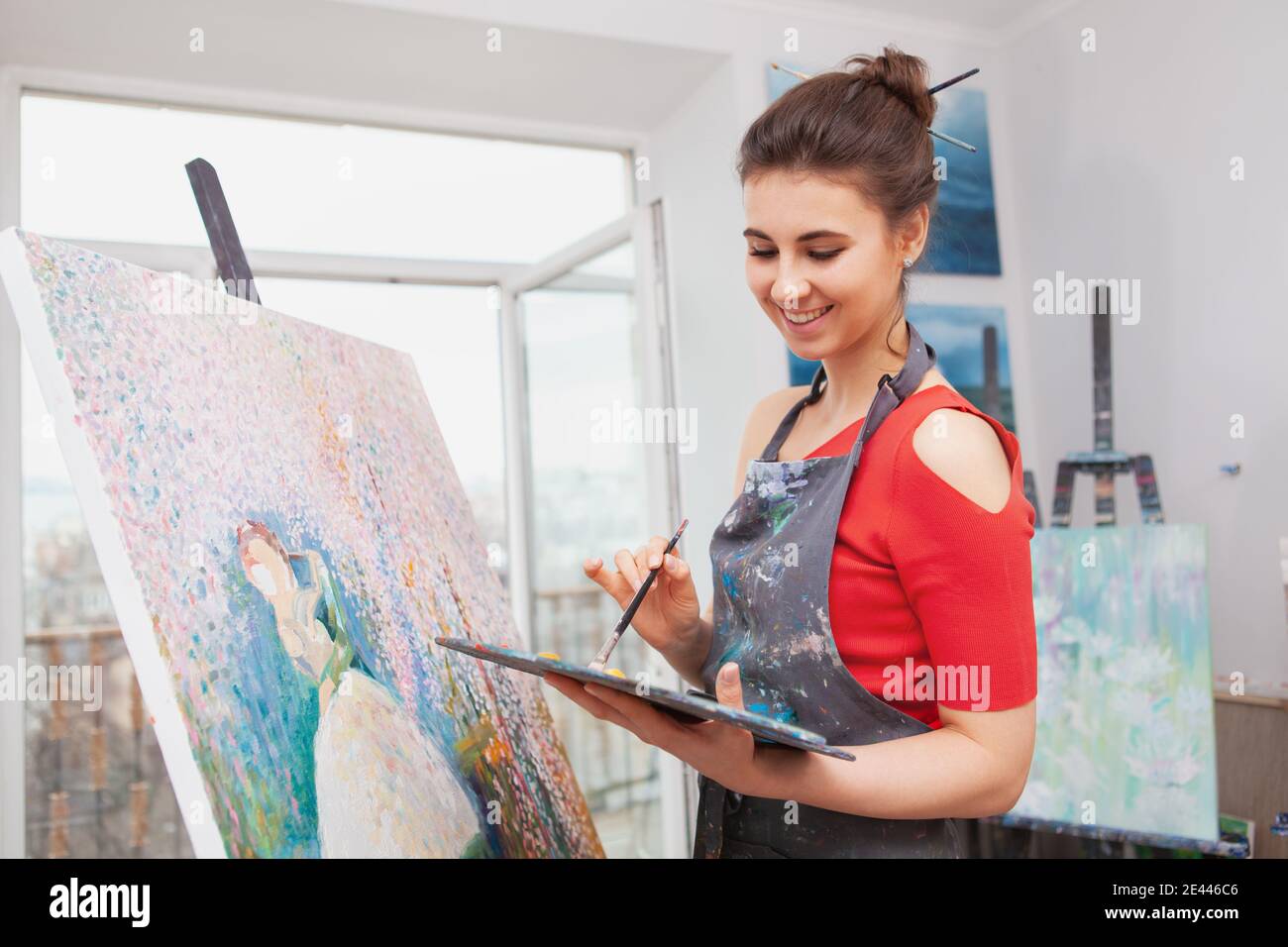 Happy beautiful woman creating an artwork at her workshop. Cheerful ...