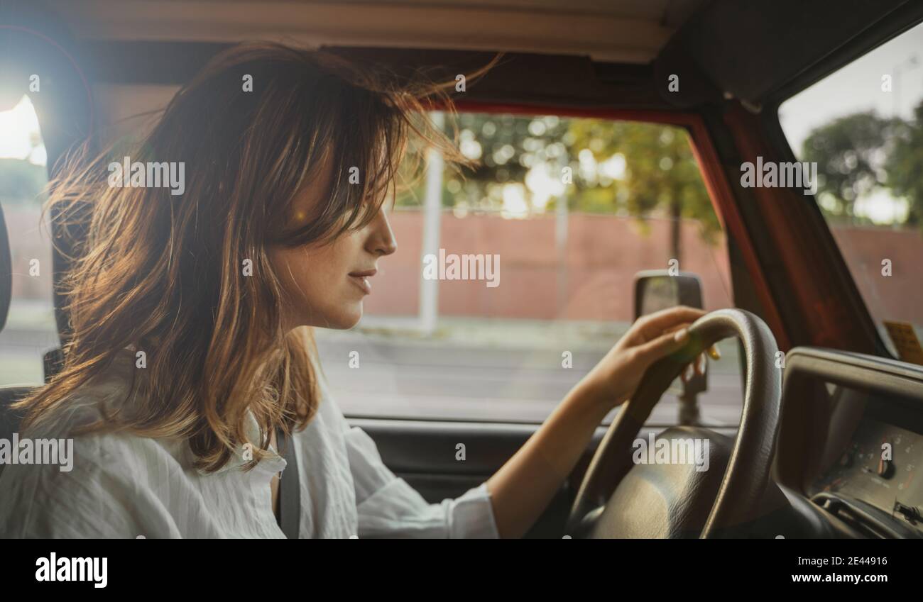 Side view of focused charming female driver sitting in automobile Stock ...