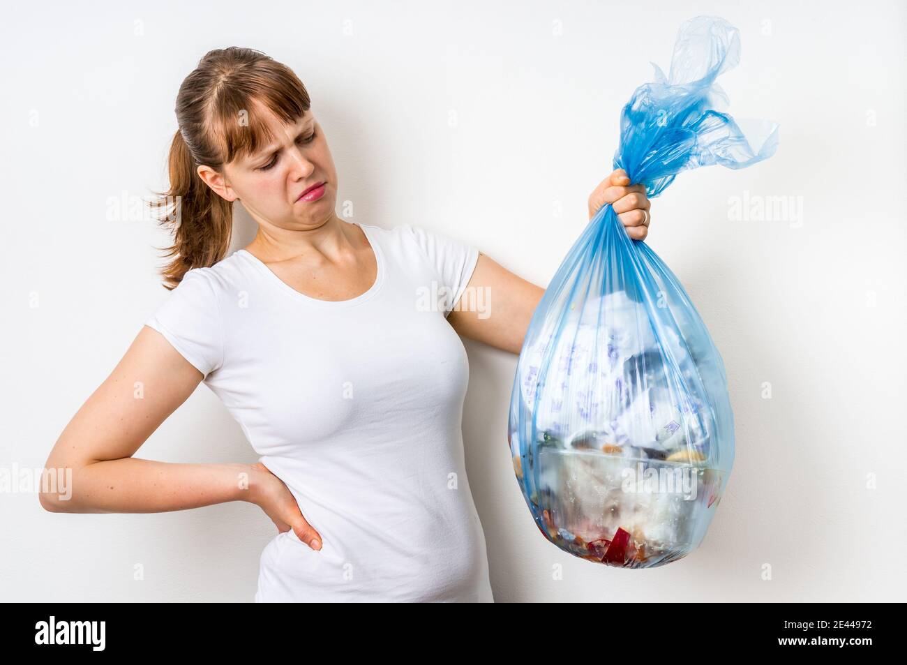 Woman holding a smelly garbage bag isolated on white background Stock ...
