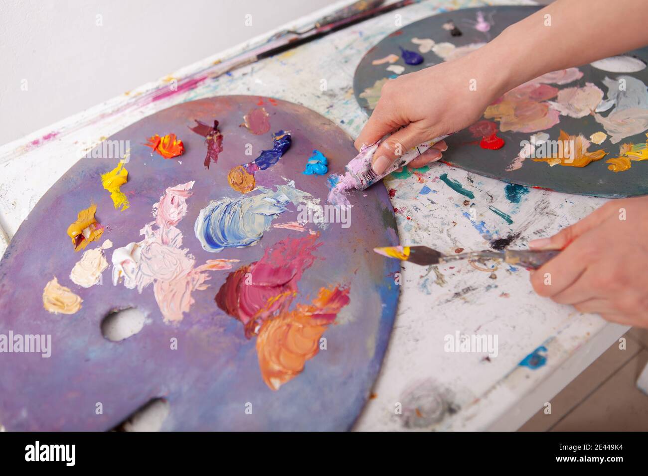 Artist squeezing oil paint on to a palette Stock Photo - Alamy