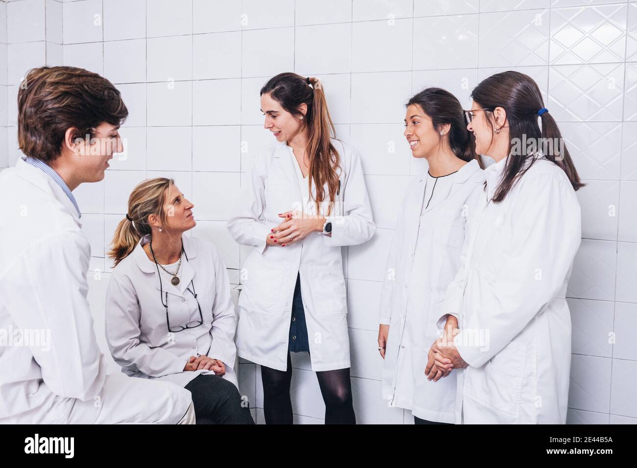 Group of doctors talking to each other with relax expression in a ...