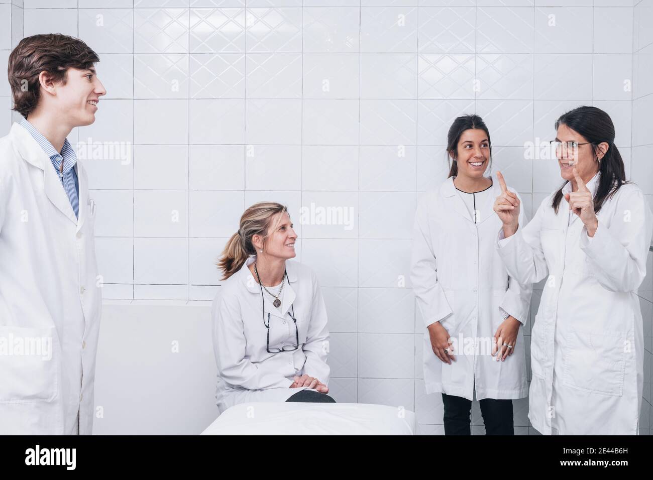 Group of doctors talking to each other in a hospital room and dressed ...