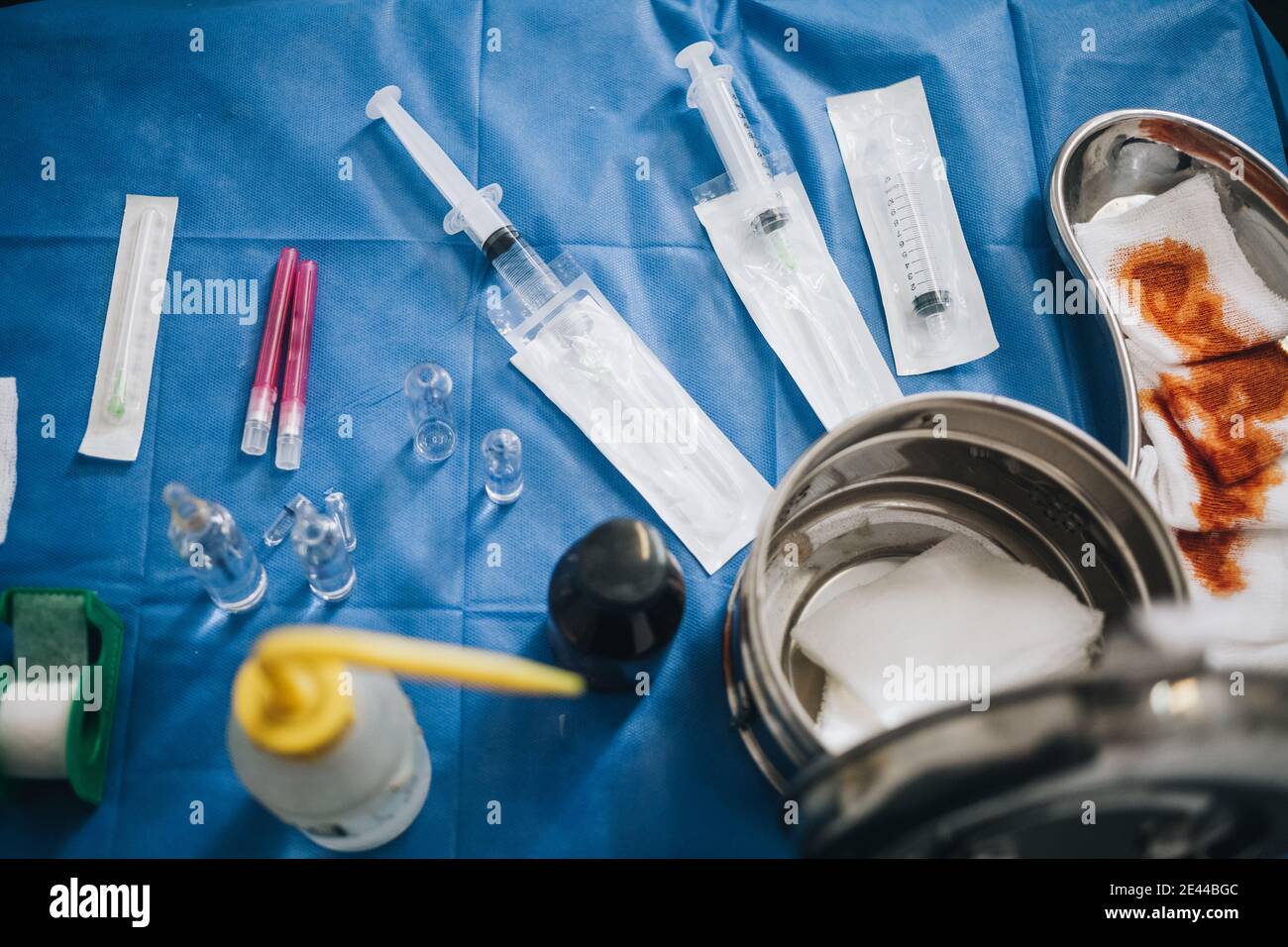 Operating room table with a blue tablecloth with needles, iodine gauze ...