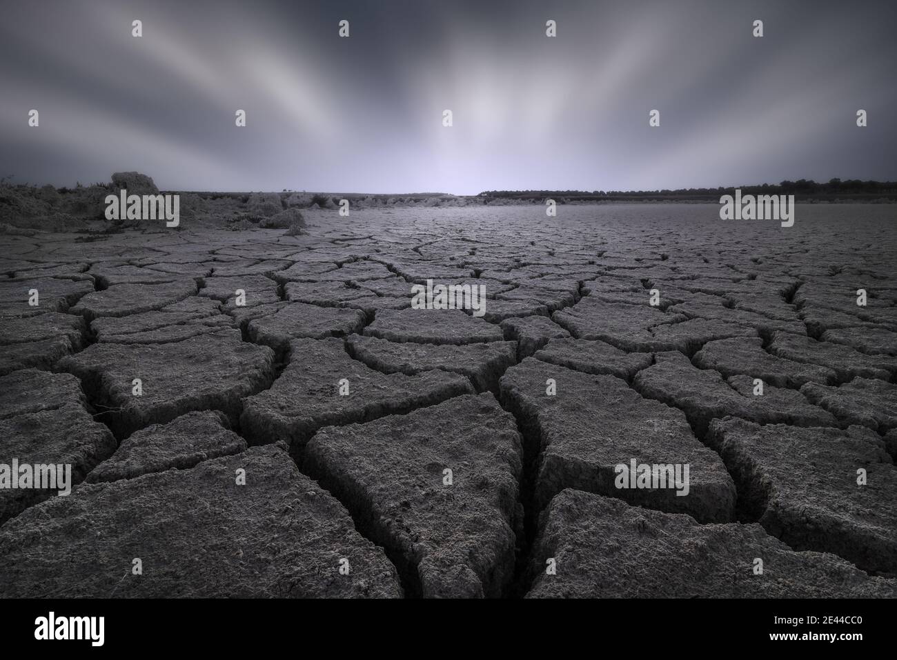 From above of drought cracked lifeless ground under colorful cloudy sky ...