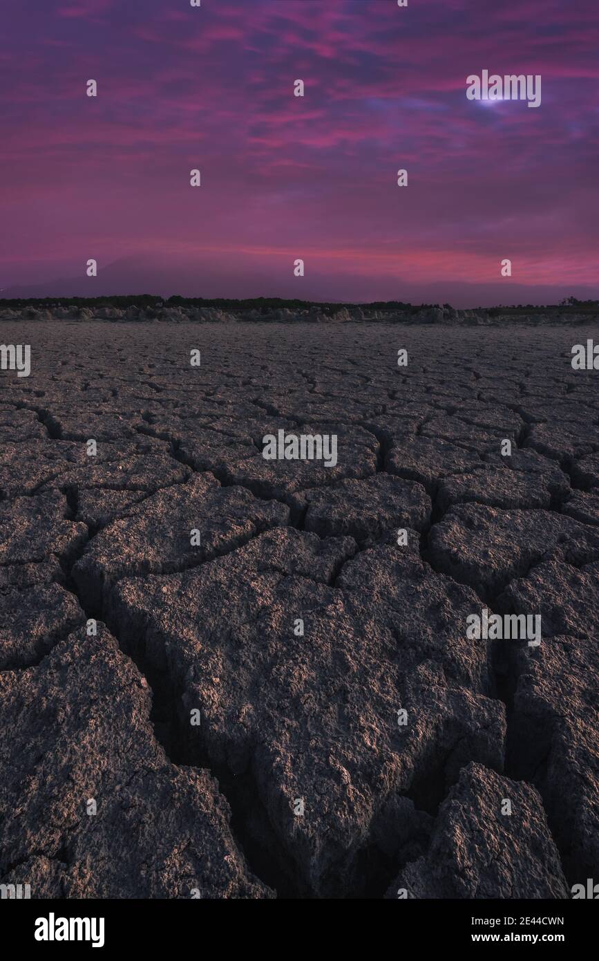 From above of drought cracked lifeless ground under colorful cloudy sky ...