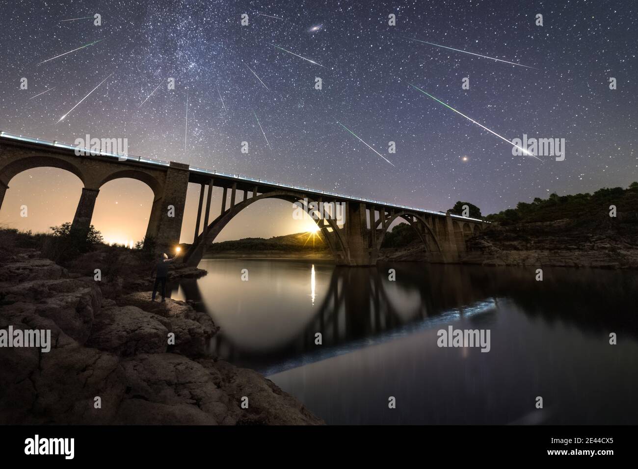 From below viaduct bridge under night sky with sparkling stars in long ...