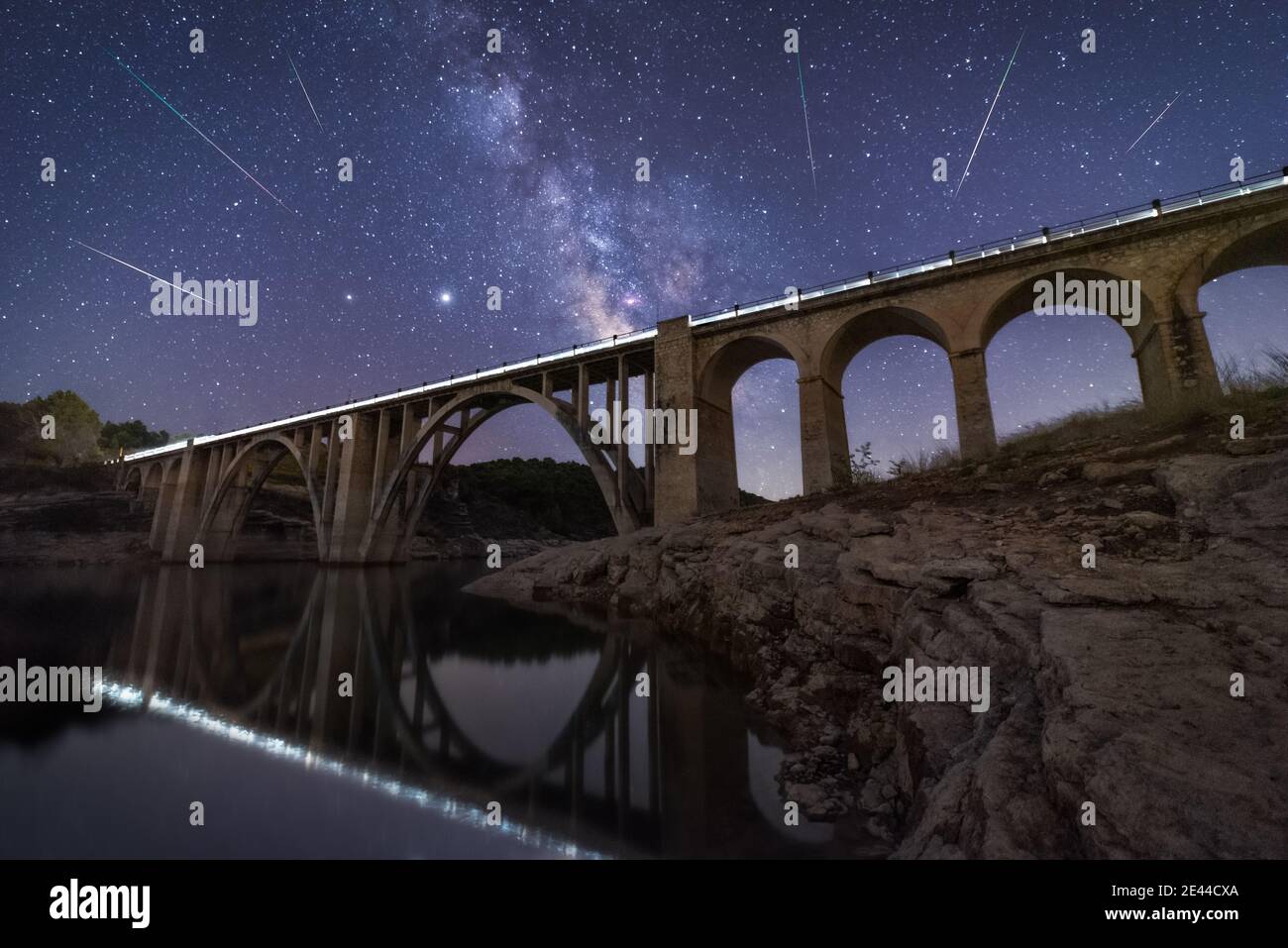 From below viaduct bridge under night sky with sparkling stars in long ...