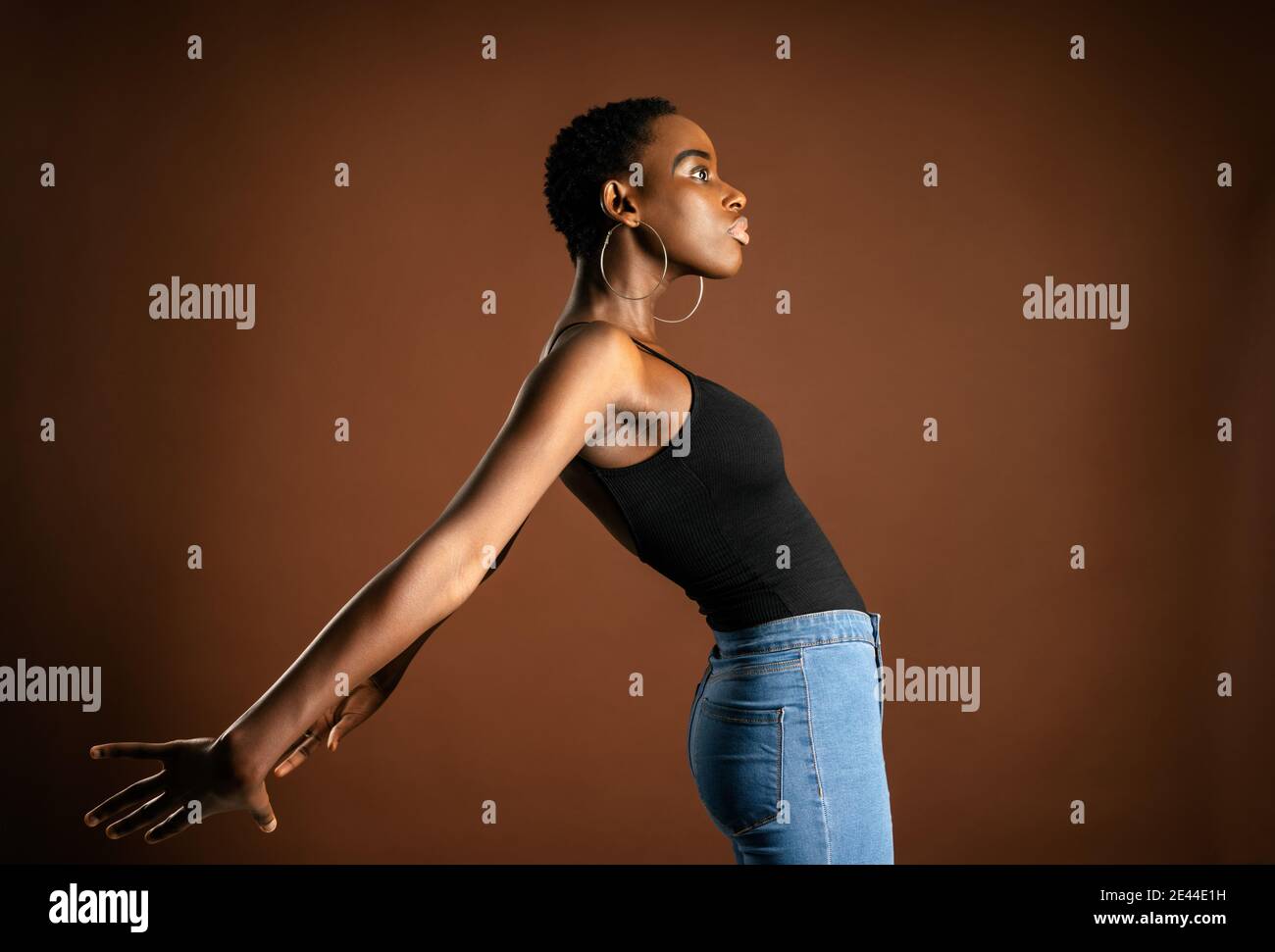 Side view of slender black Woman with short hair bending back against ...