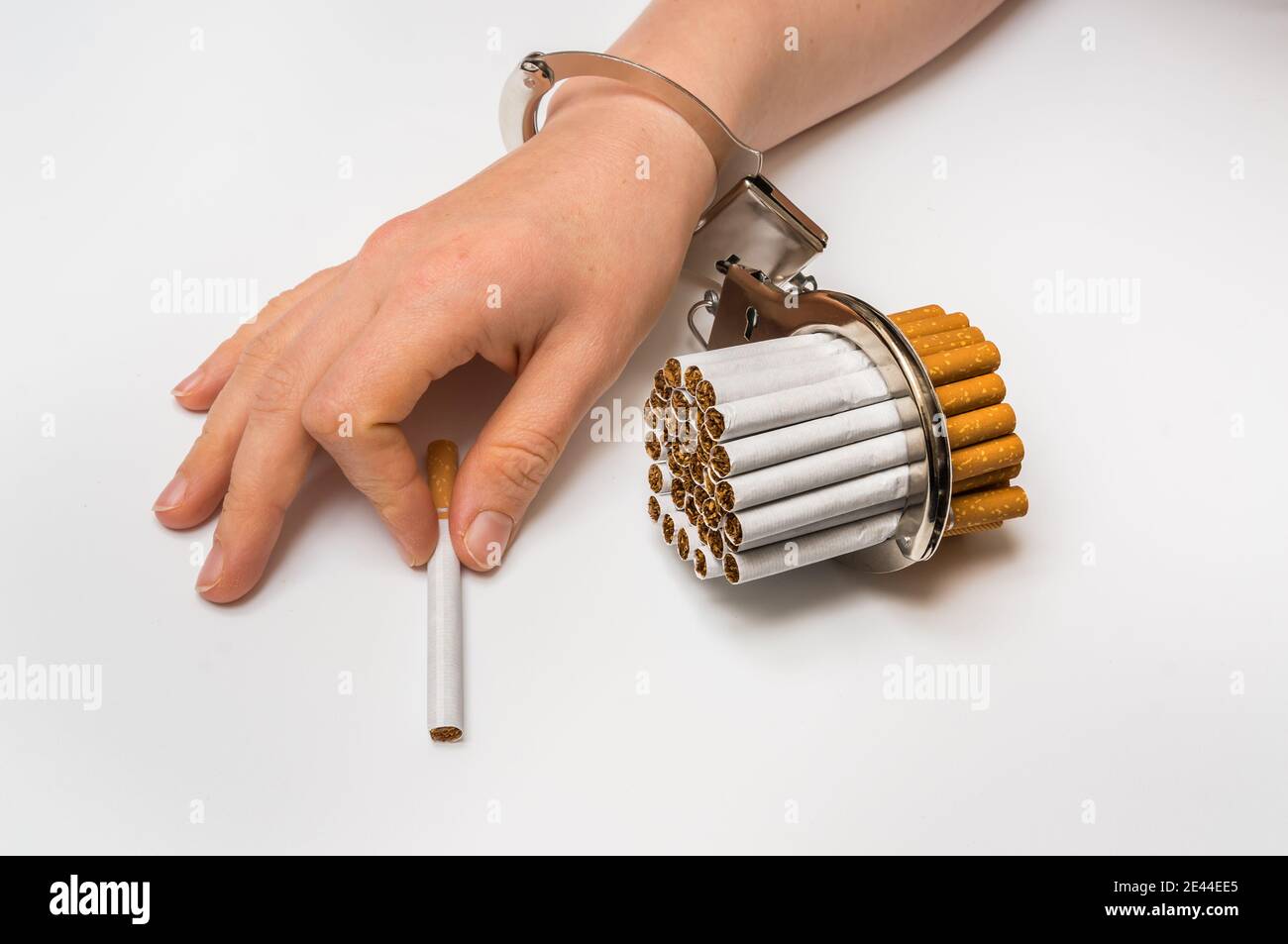Female hand with handcuffs and cigarettes on white background - concept ...