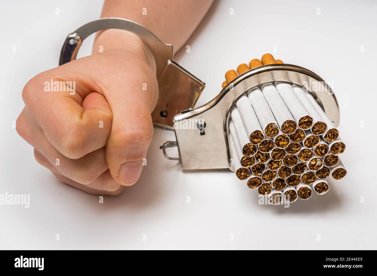 Female hand with handcuffs and cigarettes on white background - concept ...