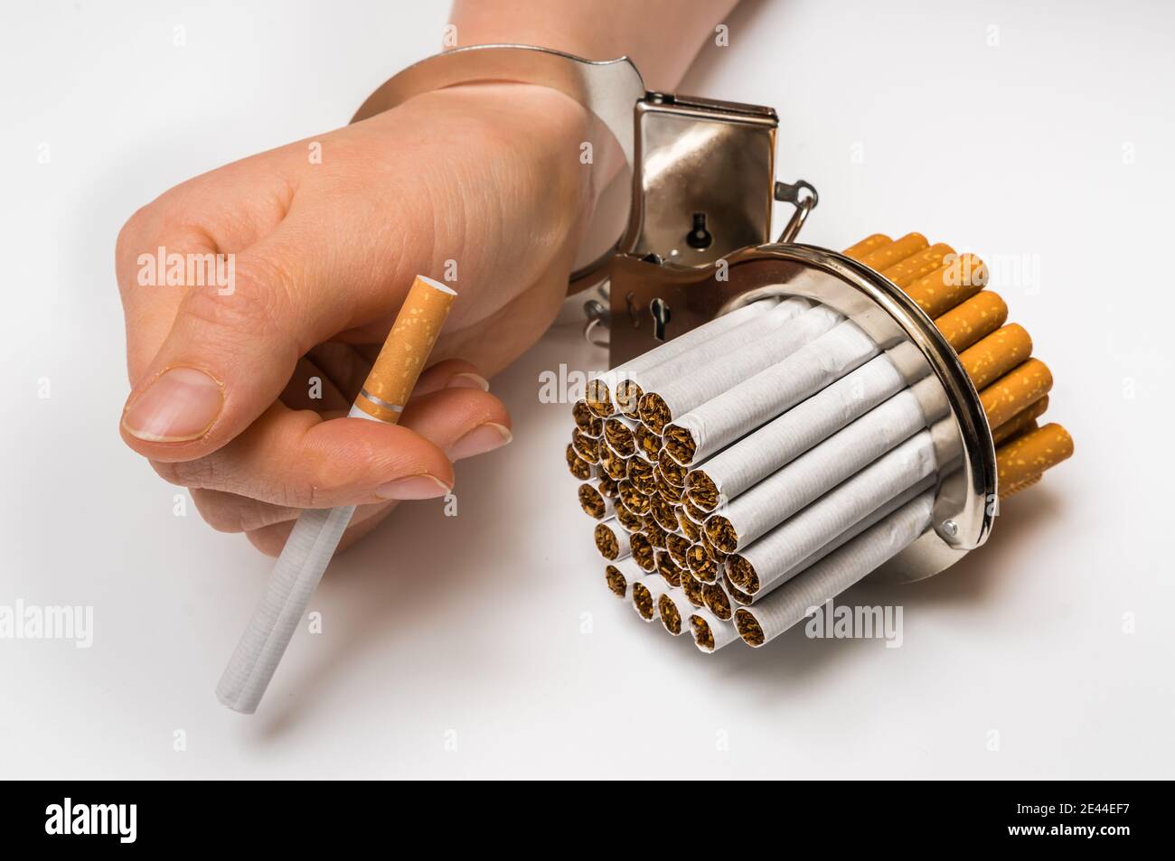 Female hand with handcuffs and cigarettes on white background - concept ...