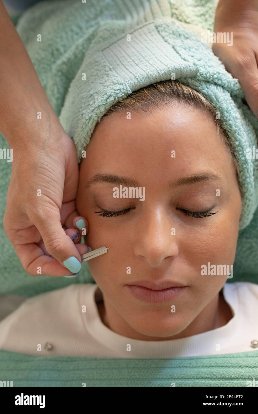 From above of crop unrecognizable cosmetician using lancet while ...