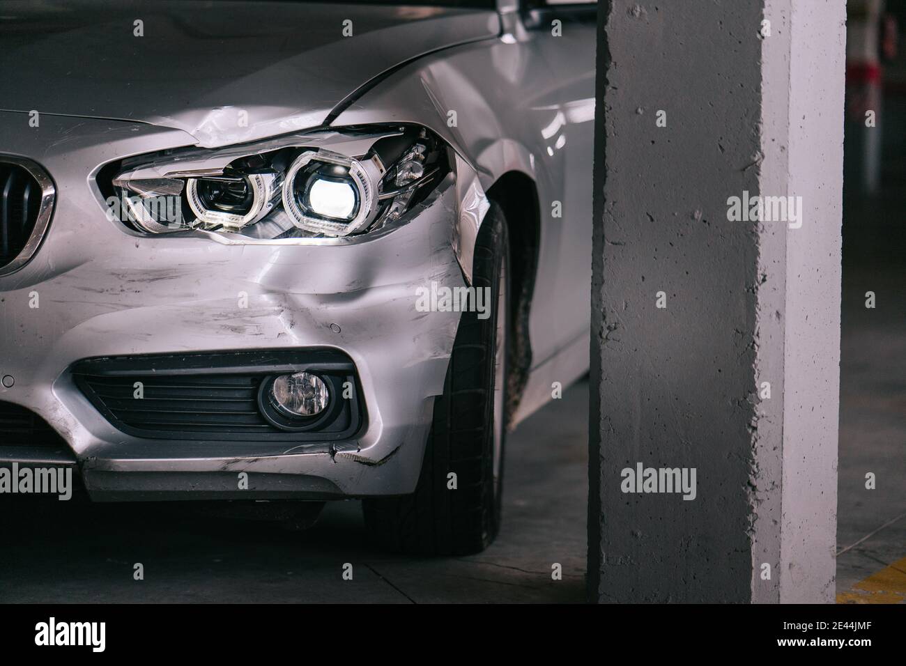 Modern car with broken headlight and damaged bumper parked near ...