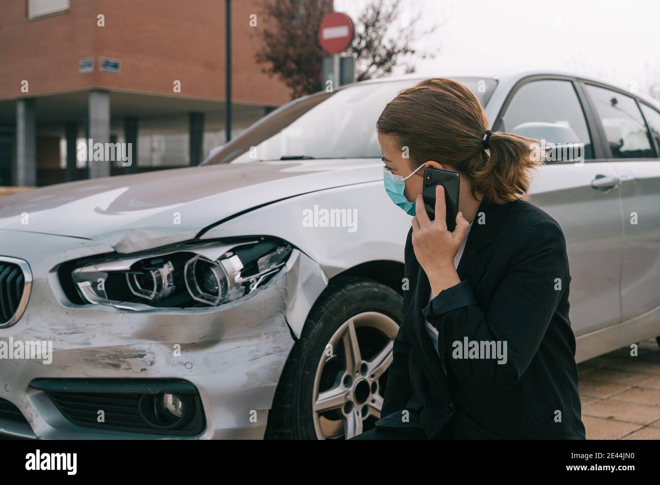 Unrecognizable young female driver in casual clothes and face mask ...