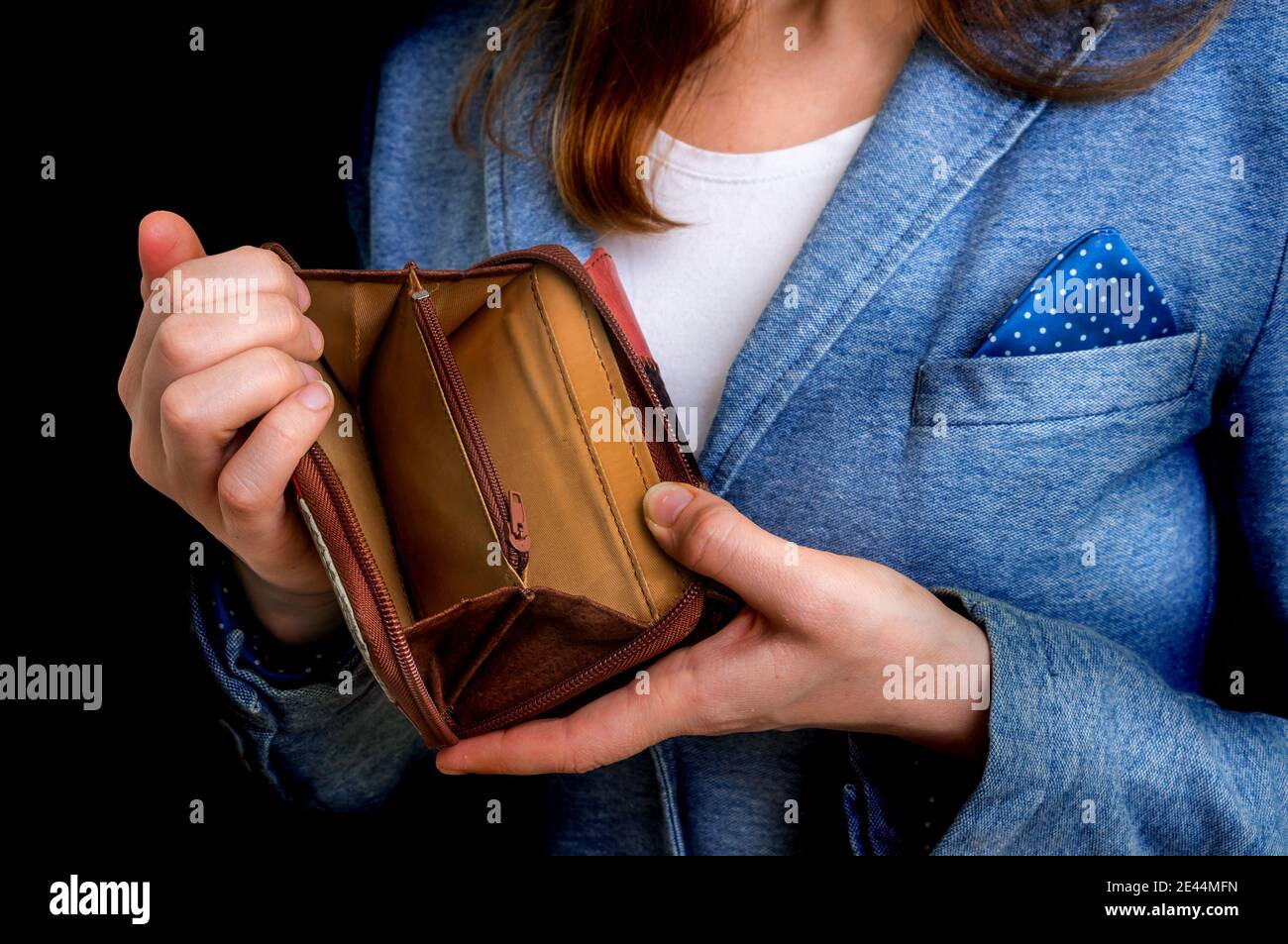 Business woman holding an empty wallet isolated on black, she hasn't ...
