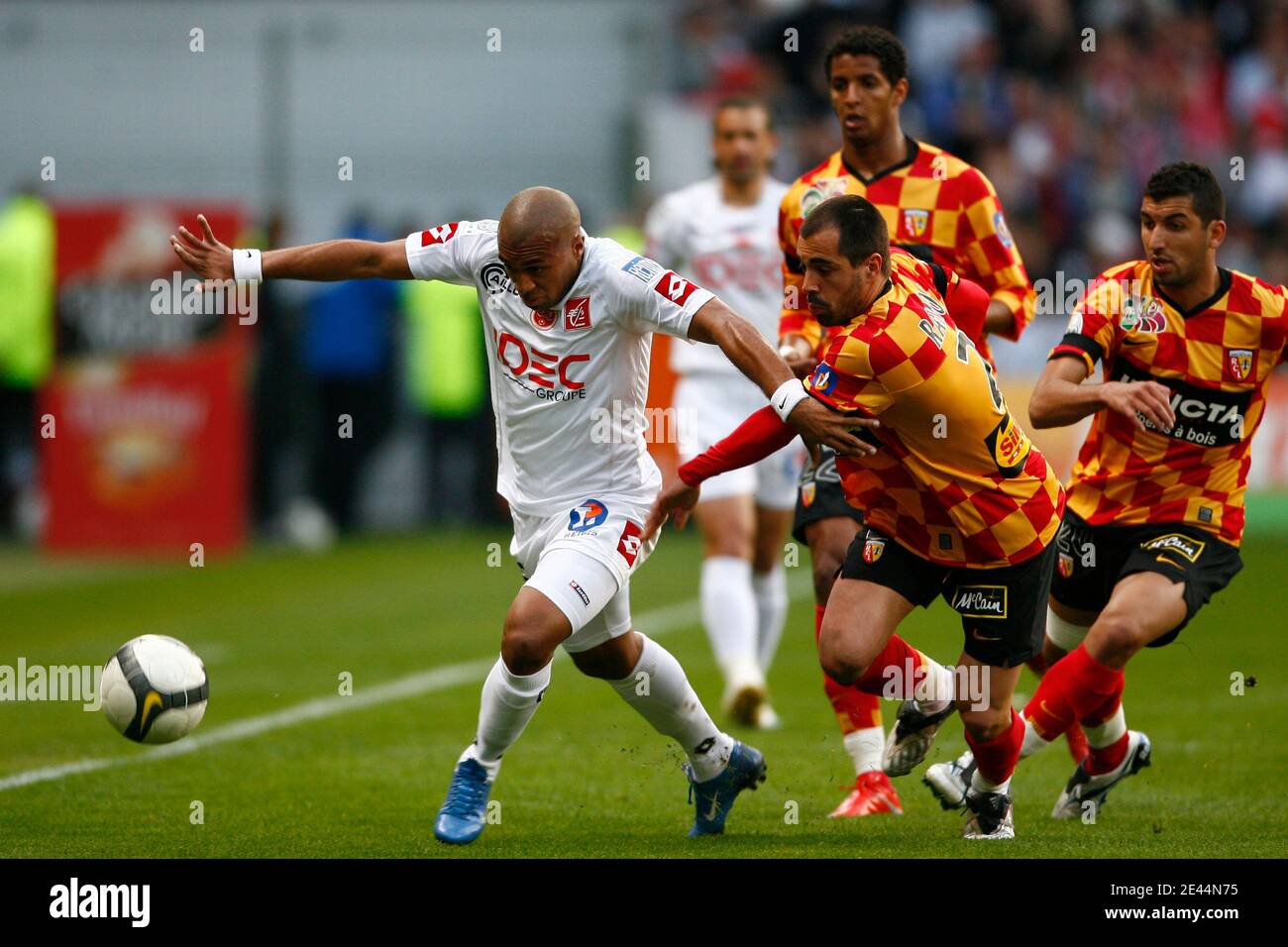 Lens' Marco Ramos (C) fights for the ball with Reims' Thomas Gamiette ...