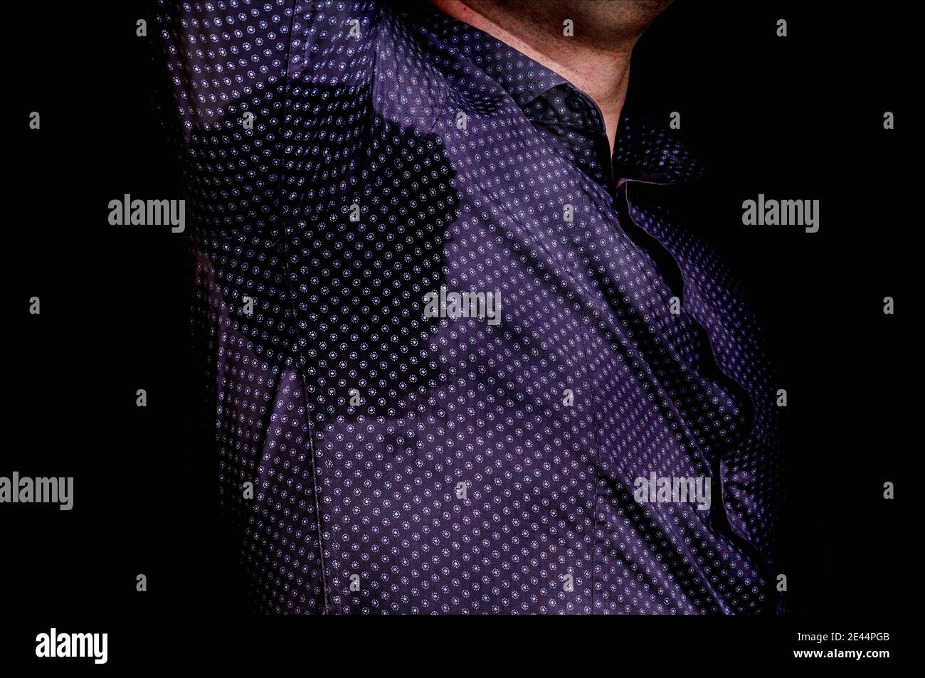 Young man with sweating under armpit isolated on black Stock Photo - Alamy