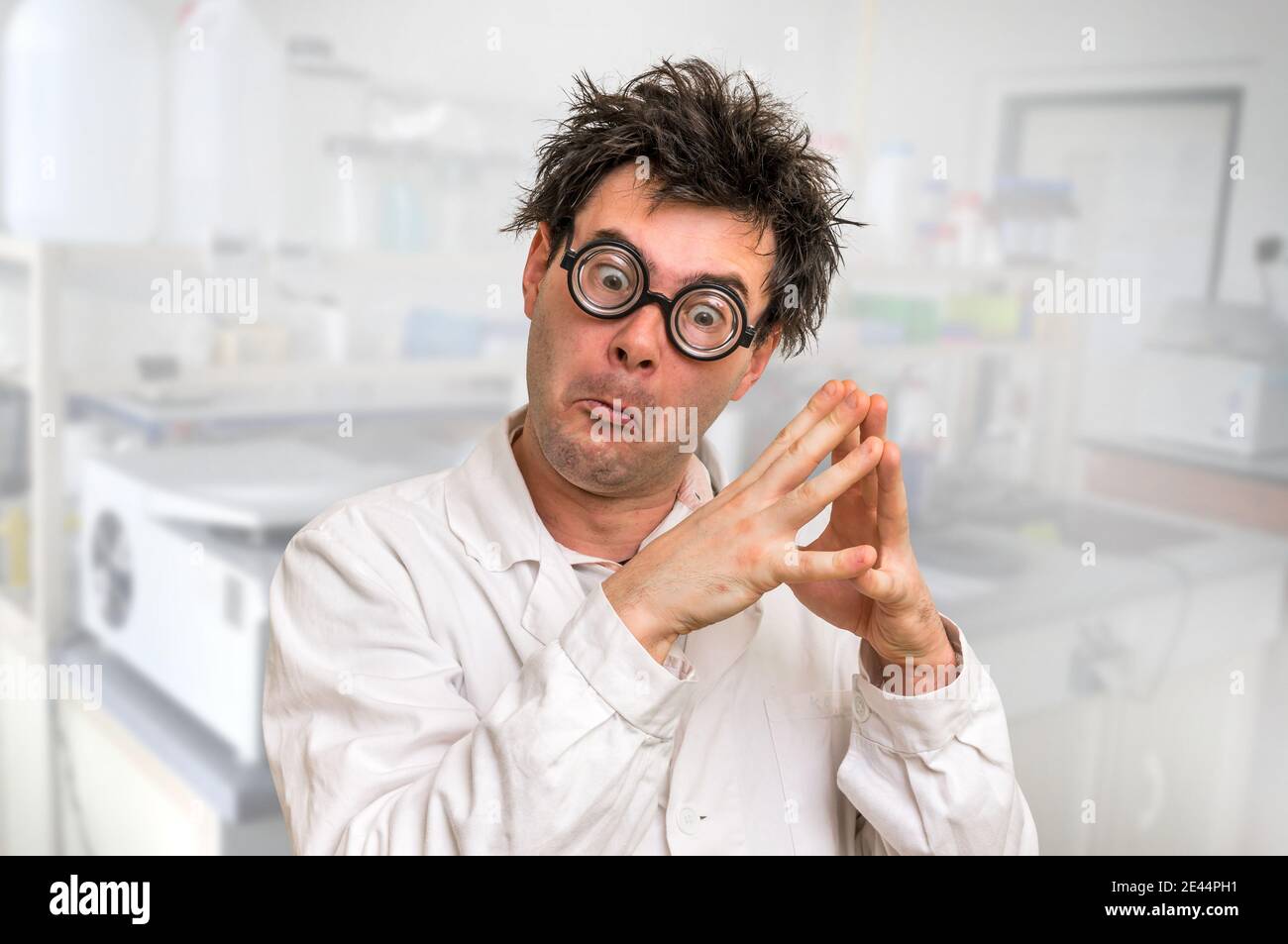 Crazy scientist with glasses thinking about his experiment in ...