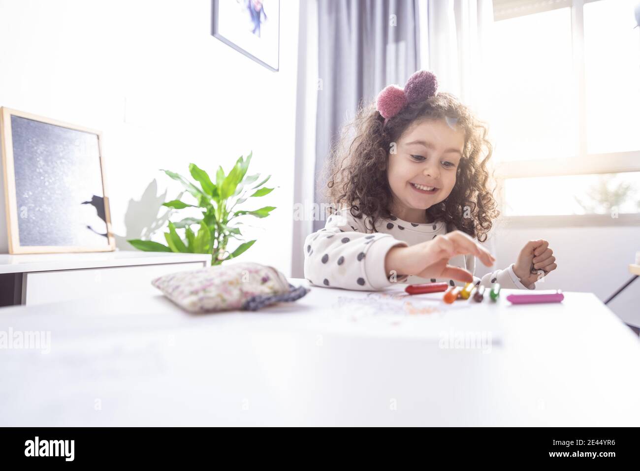 Shallow focus shot of a happy little girl painting with colorful ...