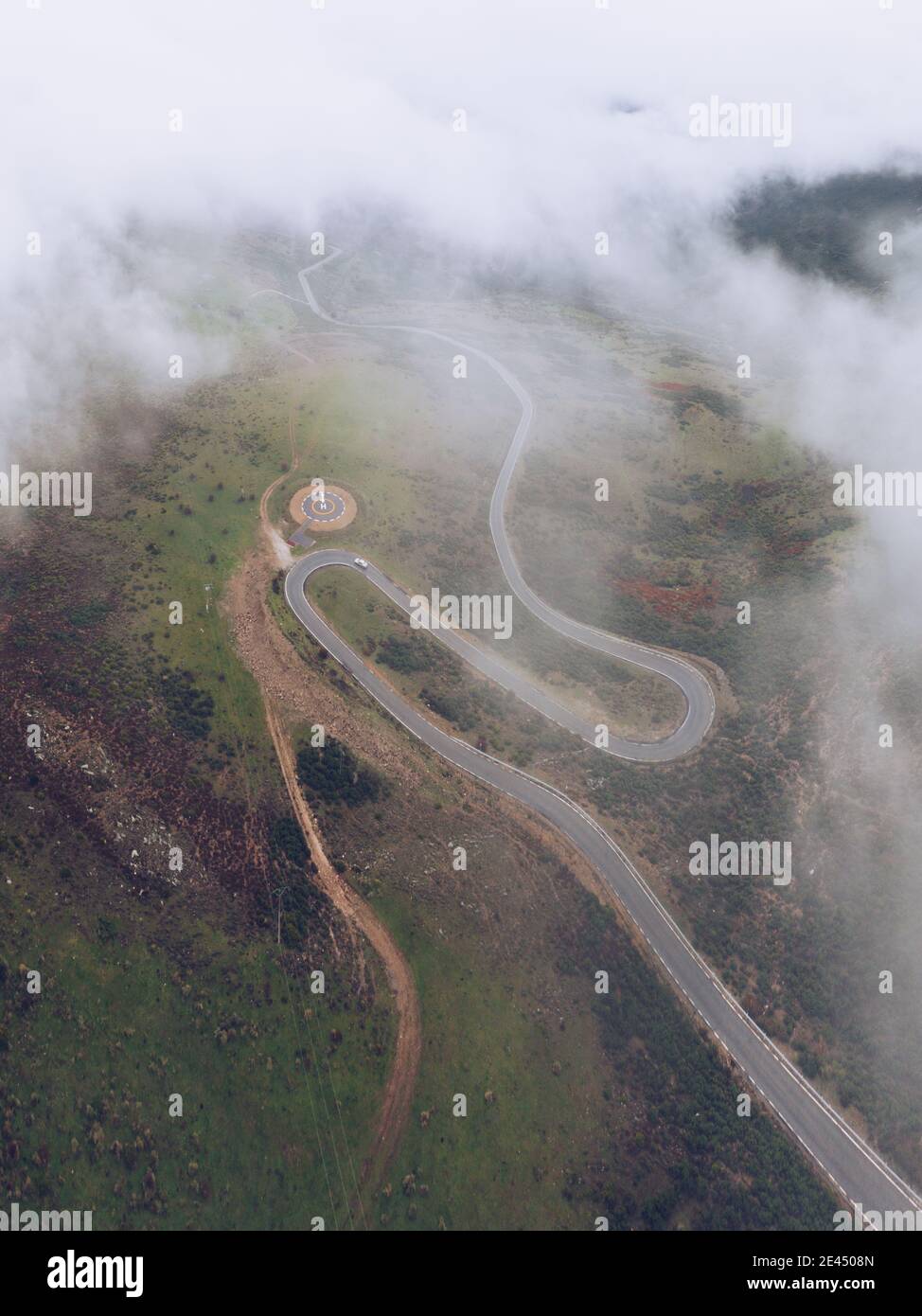 Spectacular drone view of curved serpent road near round concrete ...