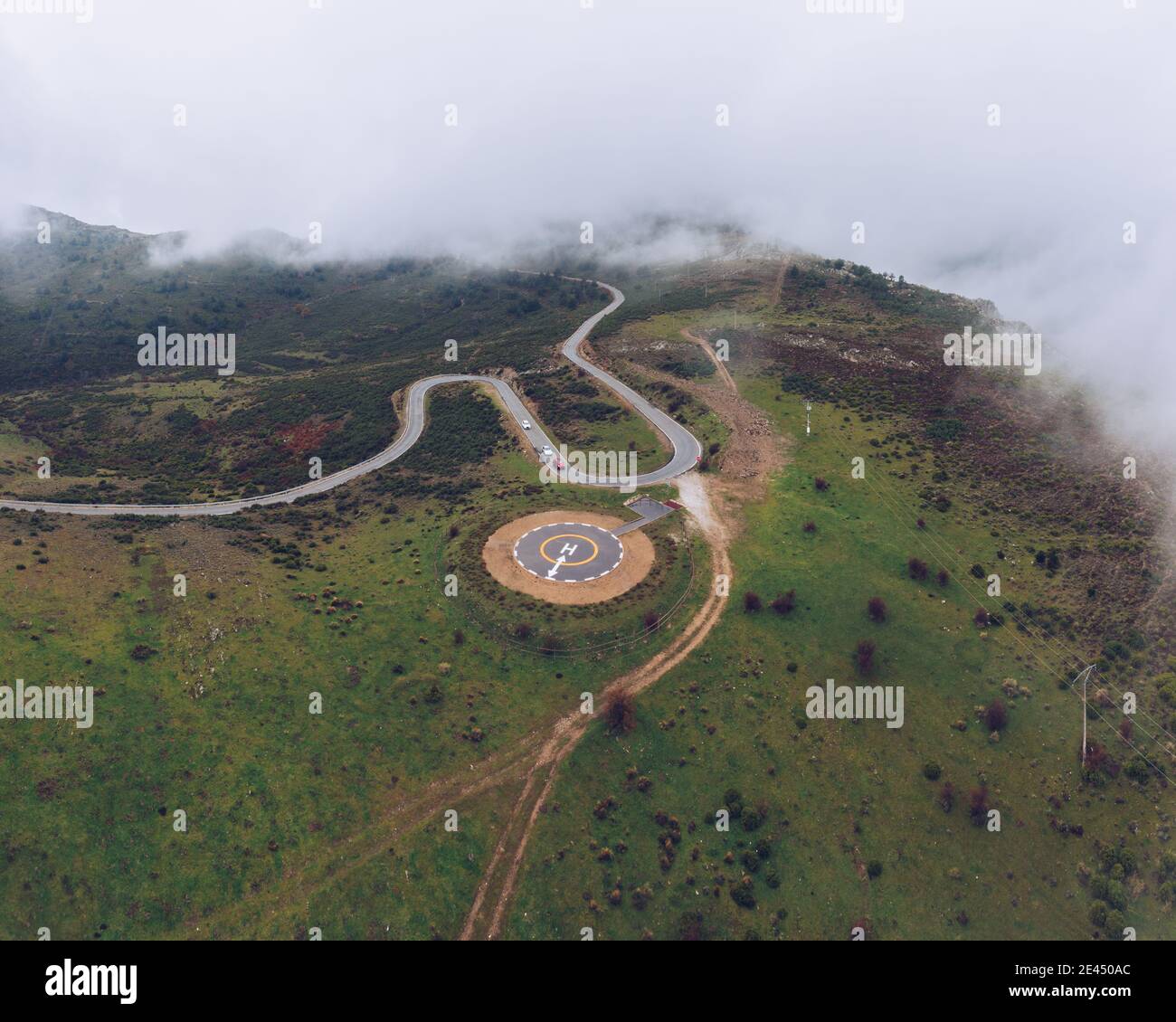 Spectacular drone view of curved serpent road near round concrete ...