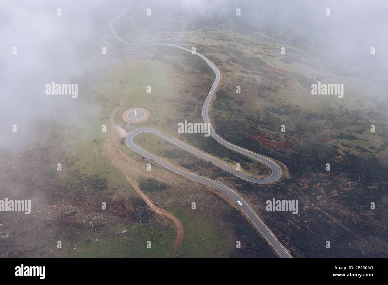 Spectacular drone view of curved serpent road near round concrete ...