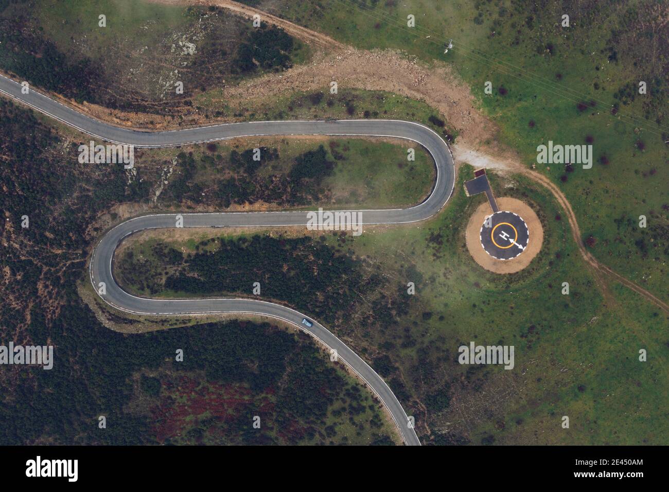 Spectacular drone view of curved serpent road near round concrete ...