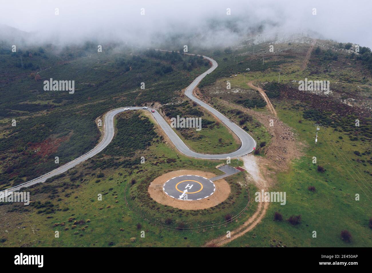 Spectacular drone view of curved serpent road near round concrete ...