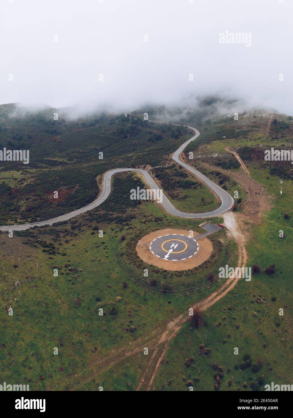 Spectacular drone view of curved serpent road near round concrete ...