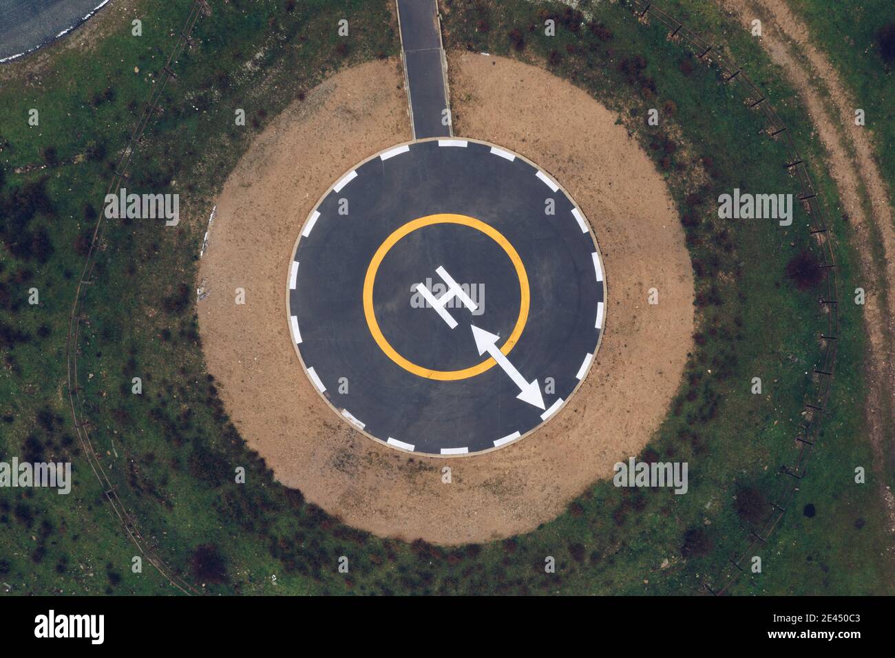 Drone top view of round concrete helipad on grassy rural valley on ...