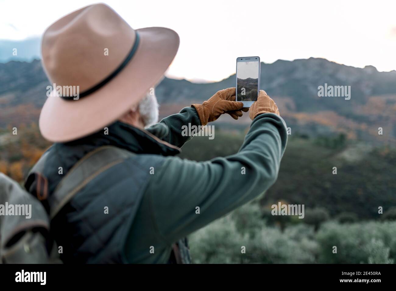 Back view of unrecognizable senior male explorer taking photo of ...