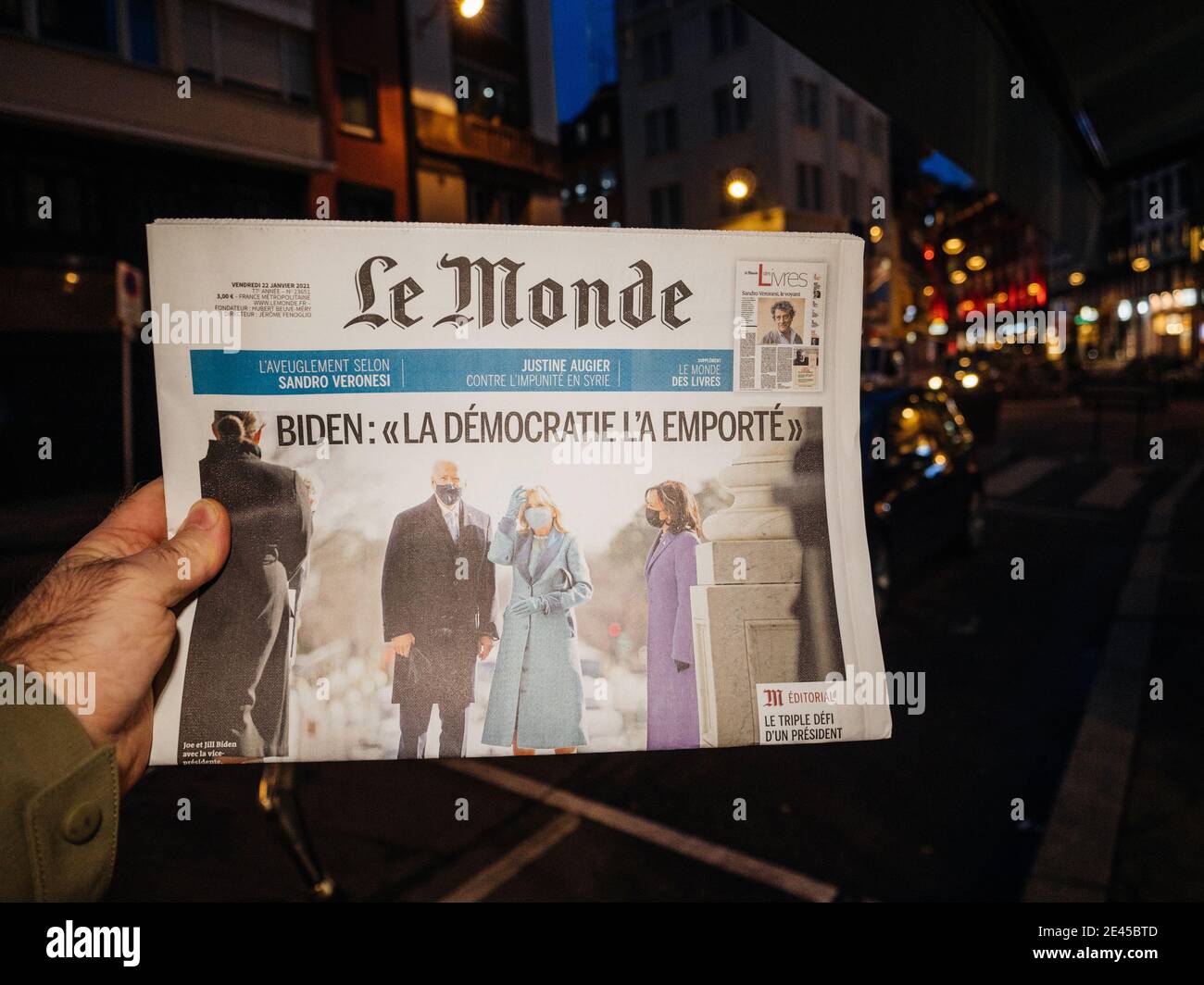 PARIS, FRANCE - JAN 21, 2021: POV hand purchases a Le Monde French ...