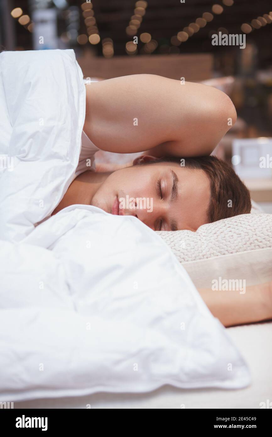 Vertical close up of a handsome young man sleeping in his bed Stock ...